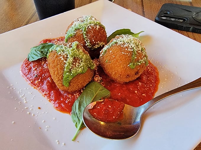 These aren't your average arancini—they're little golden orbs of happiness, dressed for success with that vibrant pesto crown.