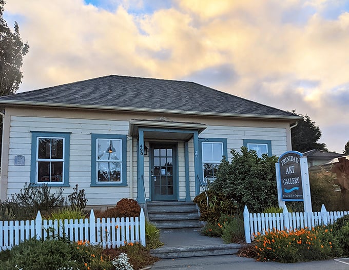Small-town art galleries like this are where creativity thrives without pretension—the white picket fence practically whispers, "Come in, we're genuine."
