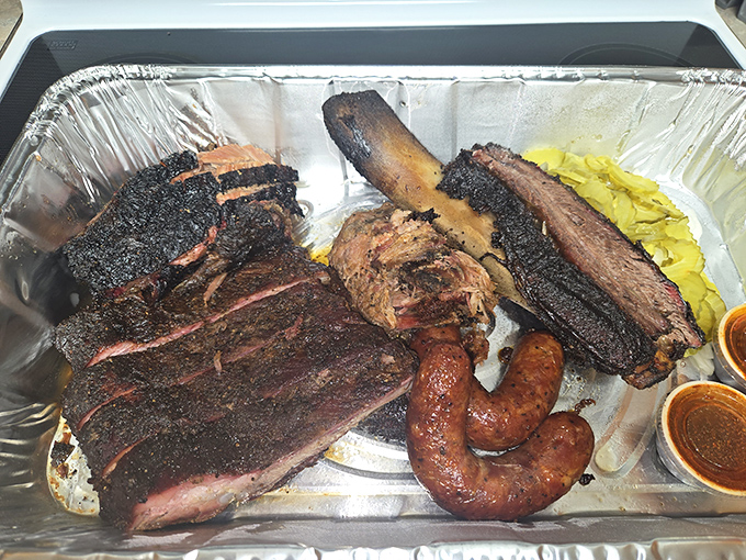 Behold, the carnivore's dream team: brisket with that perfect smoke ring, dinosaur-sized ribs, and sausage that snaps like Texas gossip.