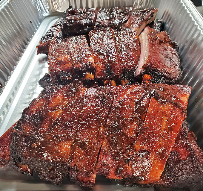 These ribs have that perfect bark that makes barbecue aficionados weak in the knees – the kind of smoke ring that tells stories of patience.