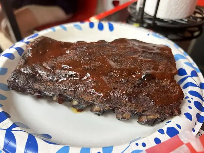 Behold, the star of the show! These ribs don't just fall off the bone—they practically leap into your mouth with smoky, saucy enthusiasm.