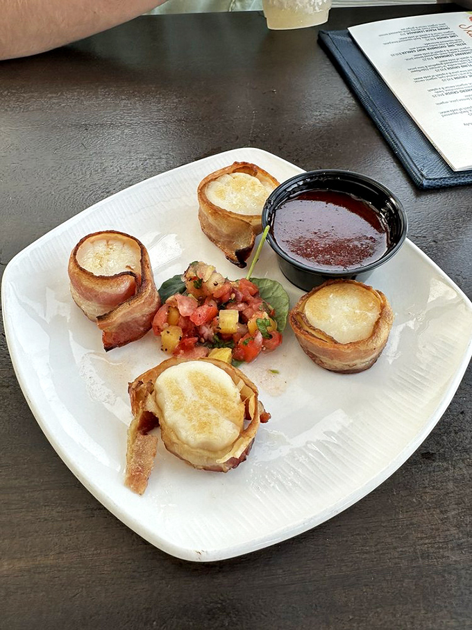 Bacon-wrapped sea scallops that could start a family feud – perfectly seared, wrapped in Applewood-smoked bacon, with a bright pineapple-tomato salsa that sings.