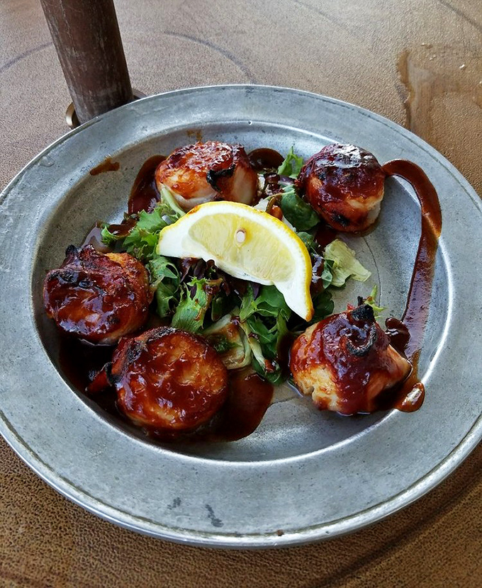 These bacon-wrapped scallops aren't just appetizers—they're little flavor bombs of sea-meets-land perfection, glazed with what must be colonial-era magic.