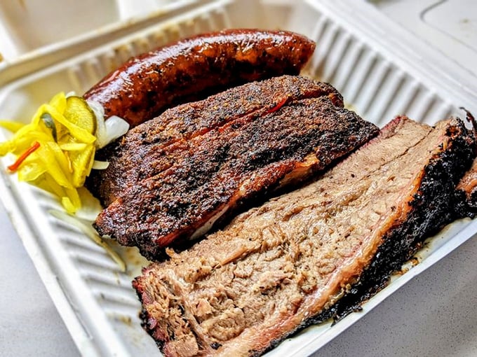 Behold the holy trinity of barbecue—brisket with that perfect smoke ring, sausage with snap, and pickles that cut through it all with zingy brightness.