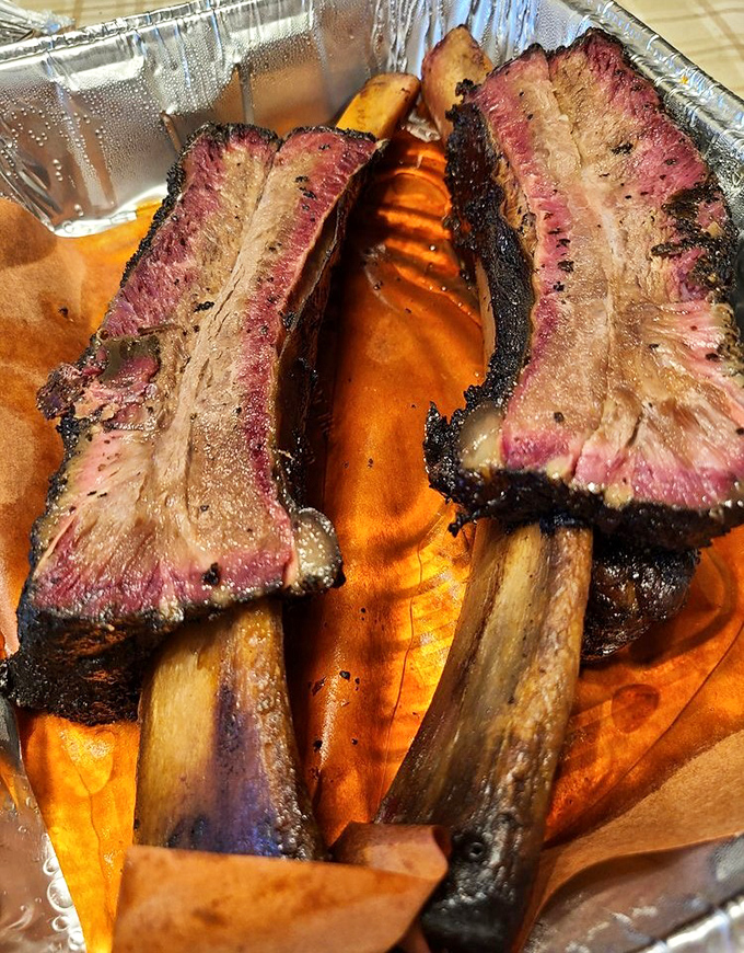These beef ribs aren't just dinner—they're prehistoric monuments to smoke and time. The pink smoke ring is nature's way of applauding the pitmaster.