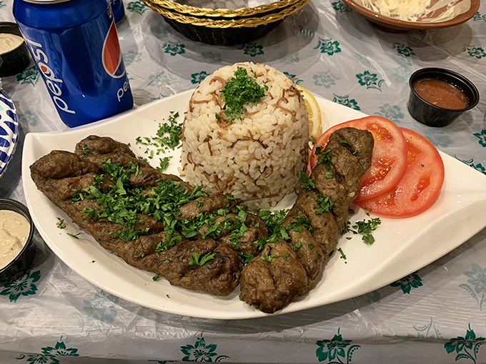 Beef kabab perfection – juicy, herb-flecked meat alongside aromatic rice and fresh tomatoes. This plate explains why locals make special trips across Orlando.