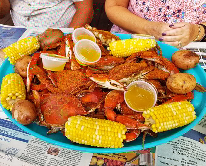 Blue crab heaven arrives on a tray with corn, potatoes, and zero pretension. Newspapers as placemats—nature's way of saying "get messy."