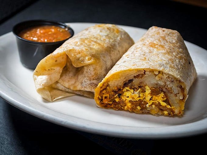 Behold the breakfast burrito in its natural habitat – perfectly grilled, stuffed with morning essentials, and accompanied by salsa that kicks your taste buds into high gear.