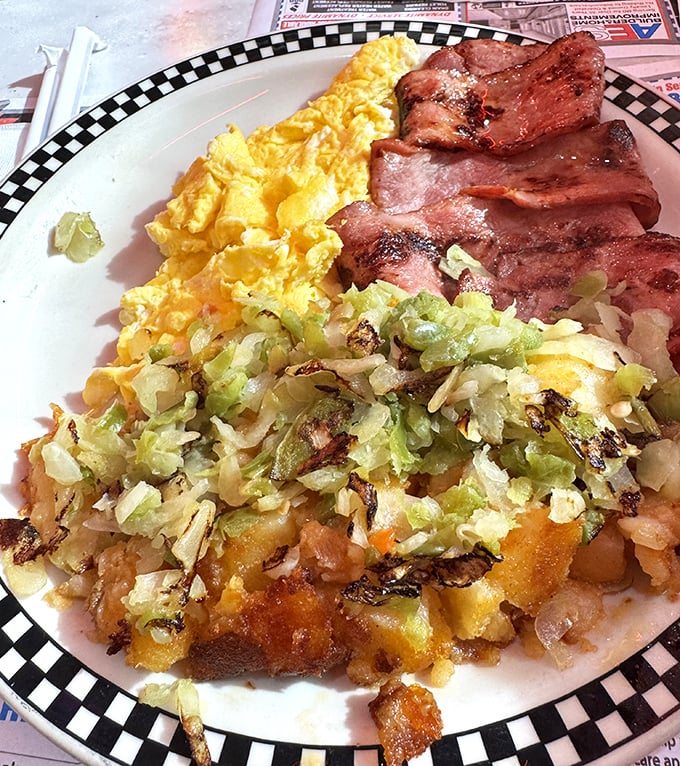 Breakfast nirvana achieved: golden scrambled eggs, crispy bacon, and home fries with grilled onions—the holy trinity of morning satisfaction.