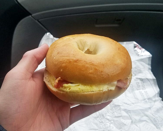 This isn't just breakfast – it's edible architecture. A perfectly toasted bagel cradles eggs and ham in a handheld masterpiece that puts fast food to shame.