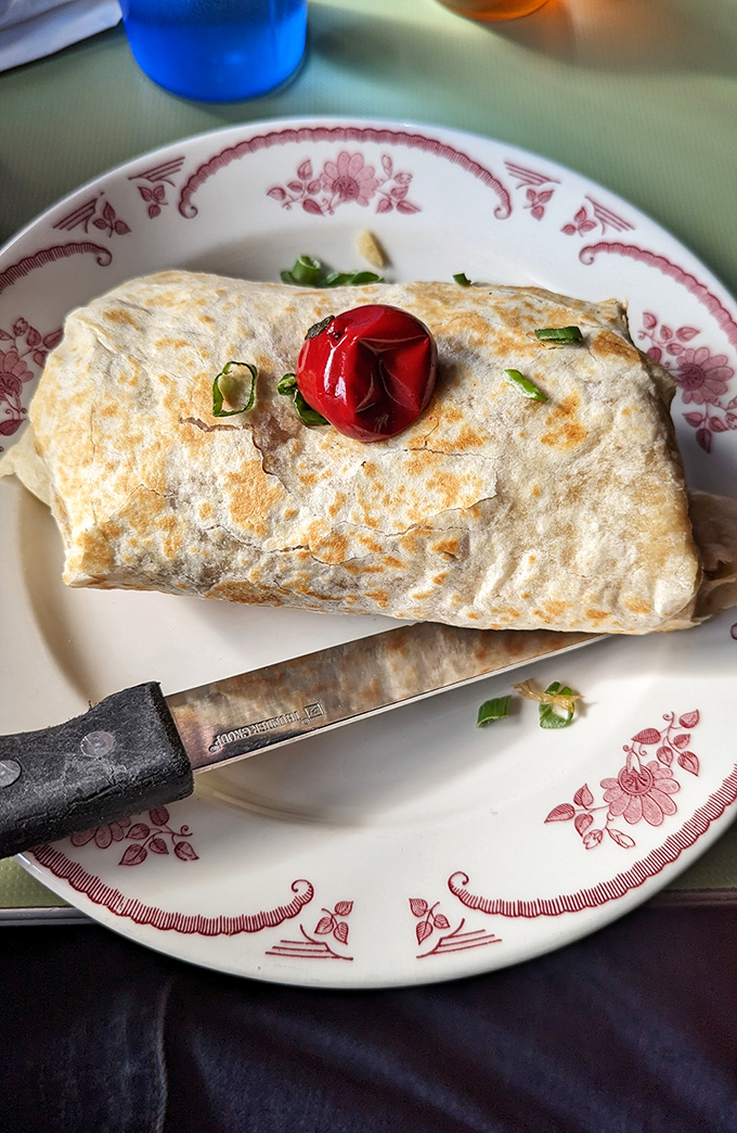 This breakfast burrito isn't just wrapped, it's embraced – a golden-grilled tortilla hugging eggs, beans, and cheese with the tenderness of a morning hug.