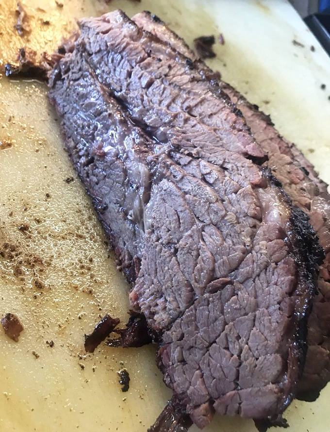Brisket so tender it practically surrenders to your fork. That smoke ring isn't just for show—it's a pink badge of barbecue honor.