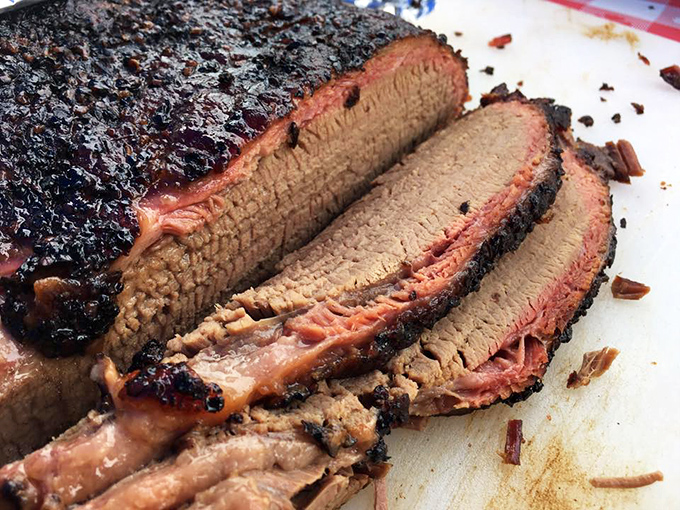 Behold the brisket in all its glory—that pink smoke ring is like nature's way of saying "you're welcome." The bark has more character than most Hollywood scripts.