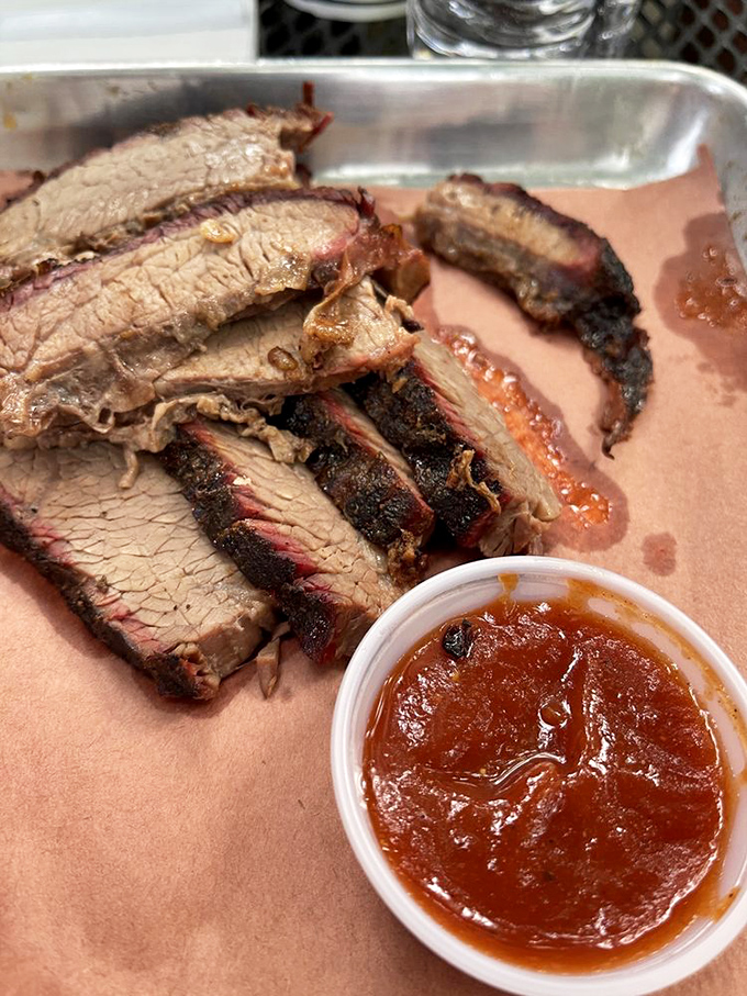 Behold the holy grail of barbecue – brisket with that telltale pink smoke ring and bark so perfect it should be hanging in the Louvre of Meat.