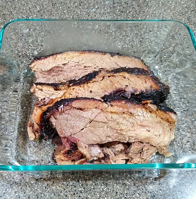 Brisket with that perfect pink smoke ring—nature's way of saying "patience rewarded." Each slice tells a story of time, smoke, and expertise.