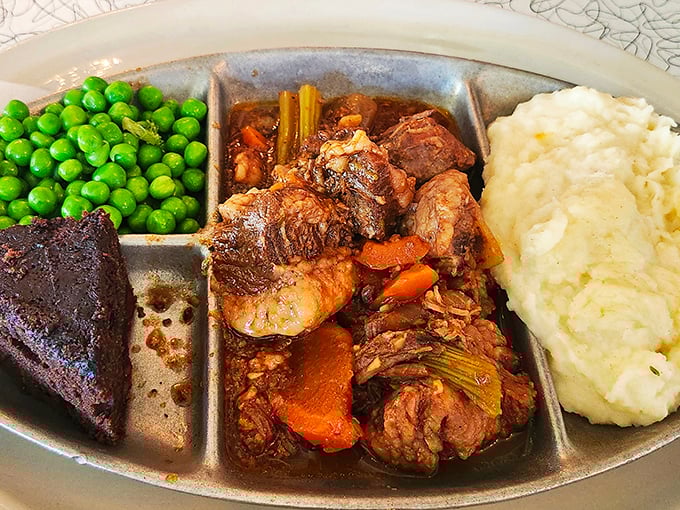 Comfort food that means business—tender brisket swimming in rich gravy alongside bright peas and cloud-like mashed potatoes. TV dinners wish they grew up to be this.