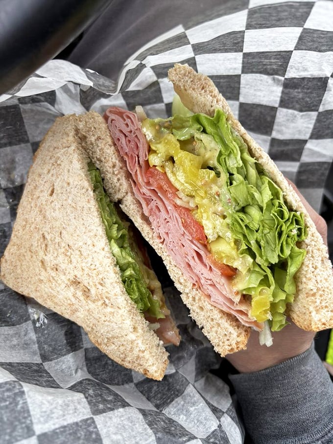 Behold the architectural marvel that is their sandwich—layers of ham, fresh veggies, and condiments stacked with more precision than the Pyramids.