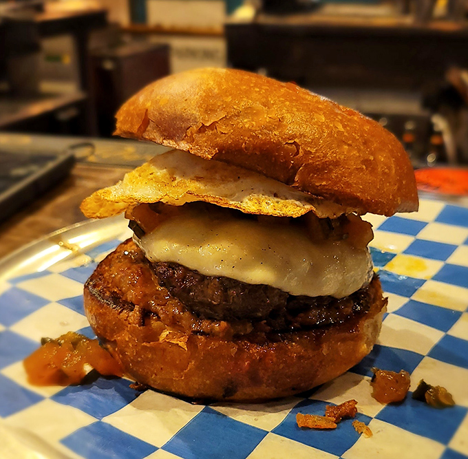 Behold the burger in its natural habitat—melty cheese cascading over a perfectly seared patty on a golden brioche throne.