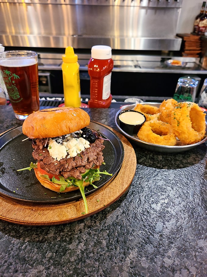 A burger that demands to be photographed before eaten, paired with golden onion rings that crunch loud enough to turn heads three tables away.