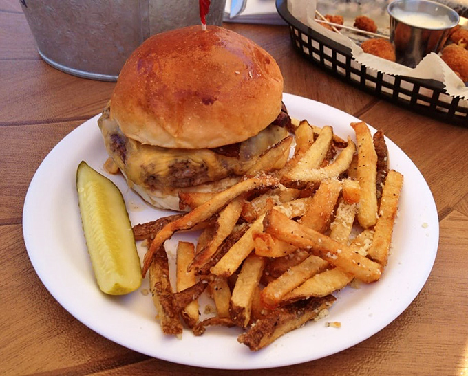 Behold burger perfection – a golden-brown bun embracing a perfectly charred patty, with crispy, seasoned fries standing guard like delicious sentinels.
