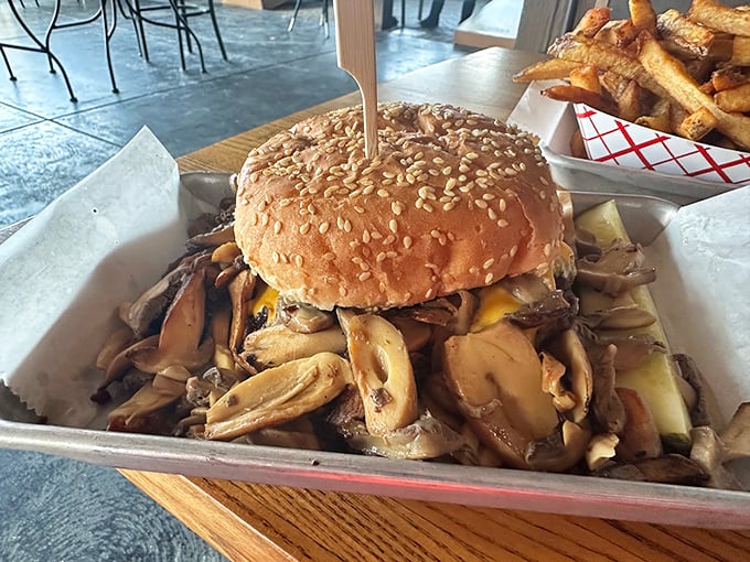 Behold the mushroom burger in all its glory—a sesame-studded bun barely containing an avalanche of sautéed mushrooms and melted cheese.