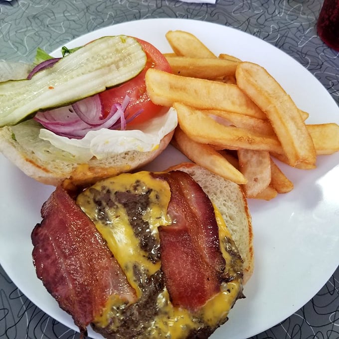 Not all heroes wear capes – some come stacked with melted cheese, crispy bacon, and fresh veggies alongside golden fries that crunch like autumn leaves.