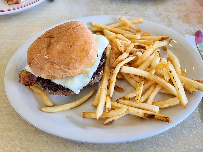 Behold, the star of our show! This burger doesn't need fancy toppings or a clever name—just perfectly seasoned beef, melty cheese, and fries that demand to be devoured.