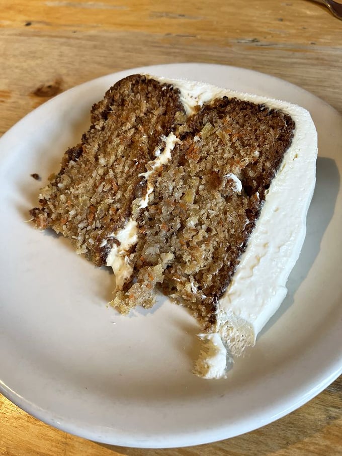 The legendary carrot cake in all its glory—moist, perfectly spiced, with cream cheese frosting that should be illegal in several states.