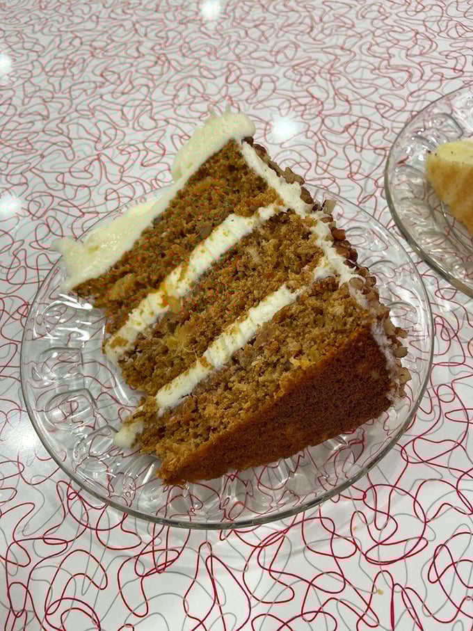 Behold the carrot cake in its natural habitat—four glorious layers proving vegetables can indeed be the star of dessert.