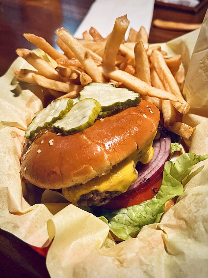 Behold the star of the show—a perfectly proportioned cheeseburger nestled among golden fries. That pickle isn't just garnish; it's essential counterpoint.