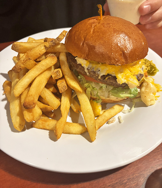 This isn't just a cheeseburger—it's architecture. The golden ratio of beef to cheese to bun, with fries standing guard like delicious sentinels.
