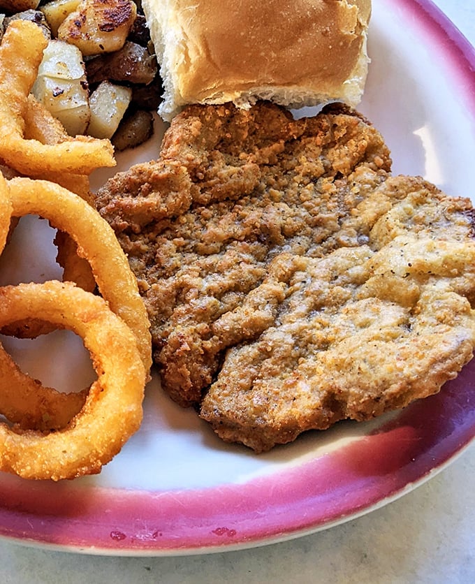 The chicken fried steak doesn't just sit on the plate—it commands attention with a golden crust that crackles with each fork pierce.