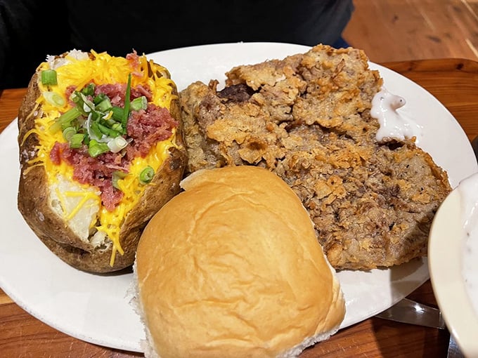 This chicken fried steak isn't just dinner—it's a crispy, golden monument to Texas cooking, complete with a loaded baked potato sidekick.