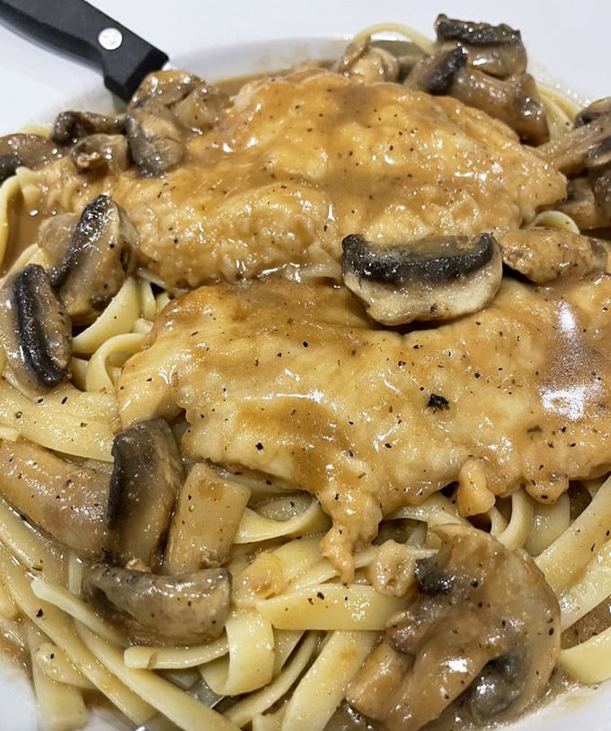 Behold the star attraction—Chicken Marsala that doesn't just sit on the plate, it performs. Those mushrooms aren't garnish, they're co-headliners.