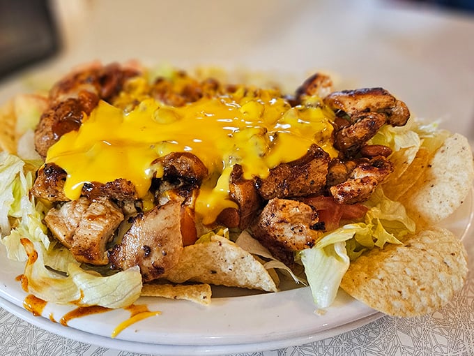 Nachos that don't know the meaning of restraint—cheese cascading over seasoned chicken like a yellow waterfall of joy.