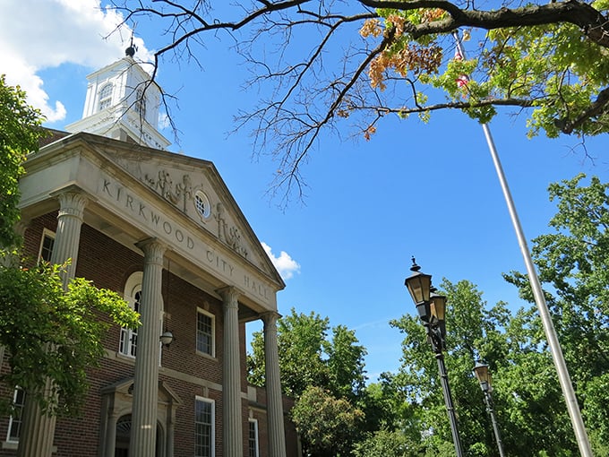 Kirkwood City Hall stands proudly like the town's unofficial patriarch—columns and brick saying "we take ourselves just seriously enough."