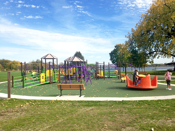 Childhood joy meets riverside serenity at Madison's playground. The kind of place where kids burn energy while parents secretly wish they could take a spin too.