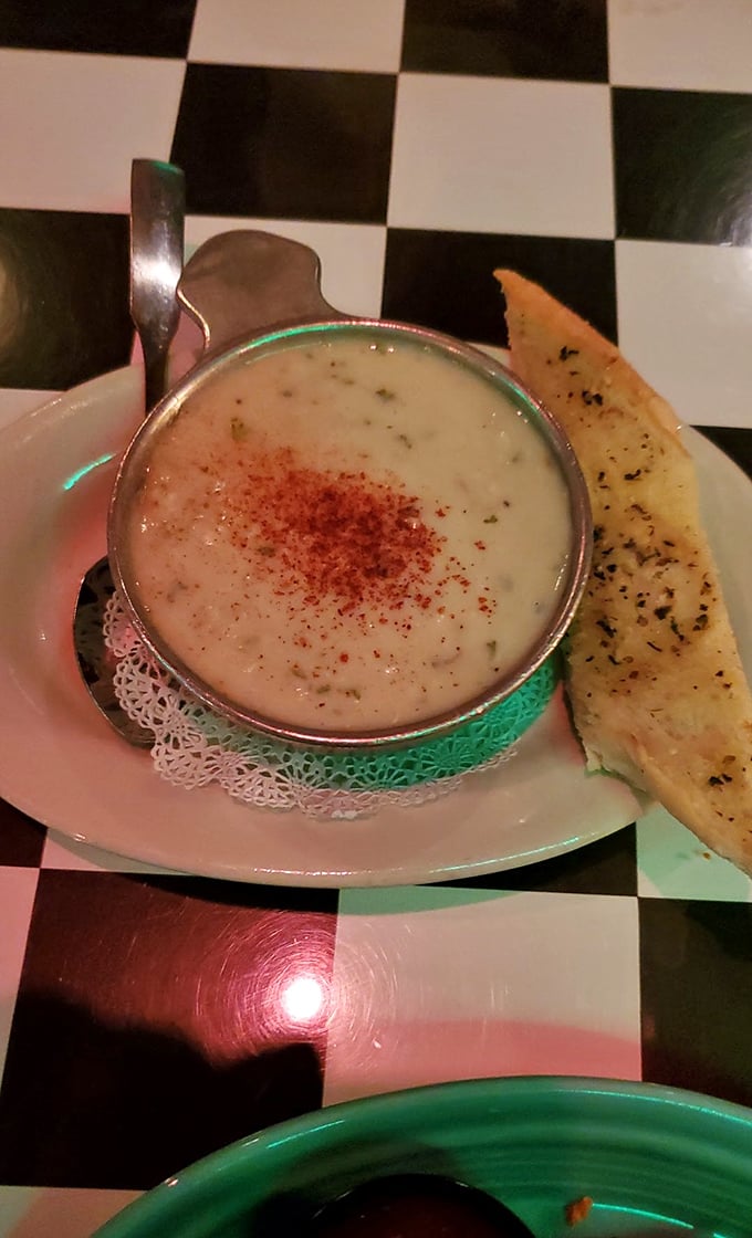 The legendary clam chowder arrives like a creamy revelation, dusted with paprika and accompanied by buttery garlic bread – comfort in a bowl that's worth every mile of the journey.