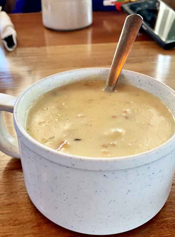 Liquid gold in a speckled mug. This clam chowder isn't just a soup—it's a creamy ocean hug that makes you wonder why you'd eat it any other way.