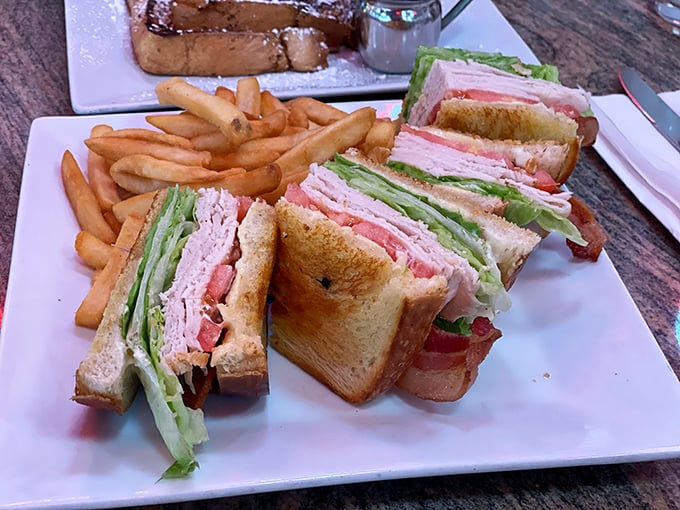 This isn't just a club sandwich – it's architectural perfection. Three stories of toasted goodness that makes vertical eating an Olympic sport.