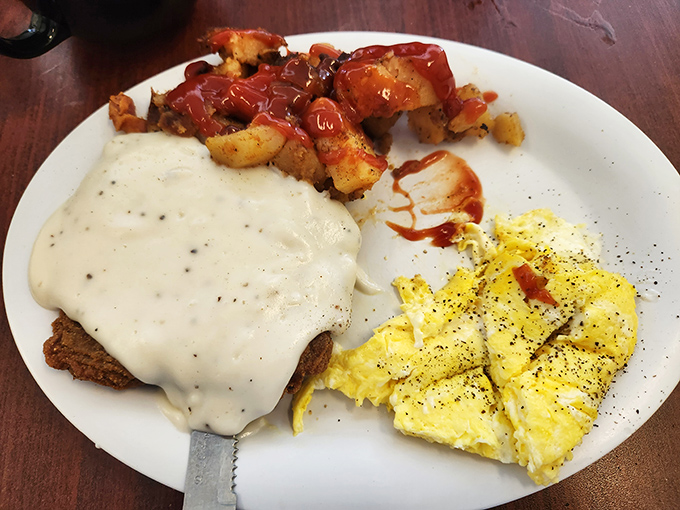 Country fried steak smothered in peppery gravy alongside fluffy scrambled eggs—proof that breakfast can indeed be the most important meal of the day.