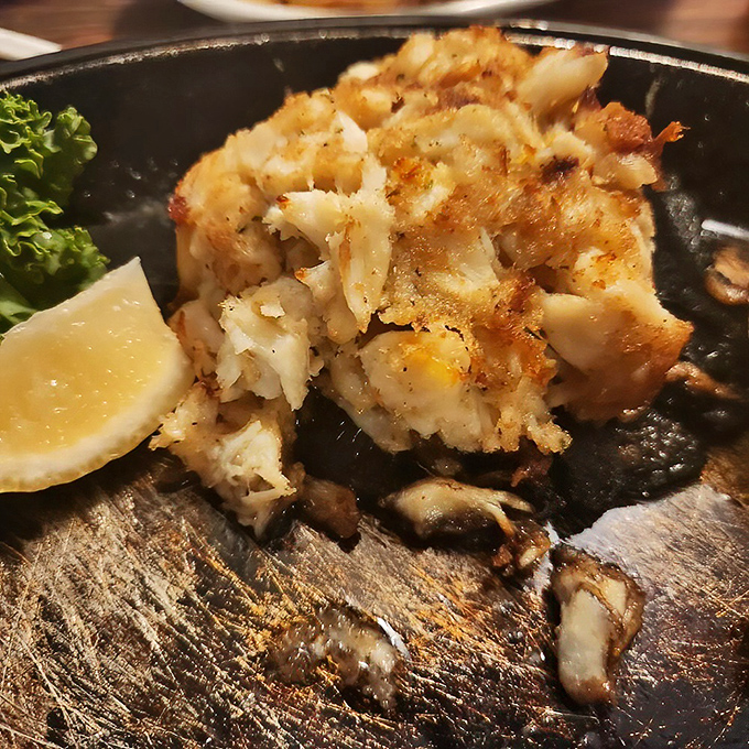 This crab cake isn't just food; it's architecture. Golden-brown exterior giving way to sweet, delicate crabmeat—the seafood equivalent of striking gold.