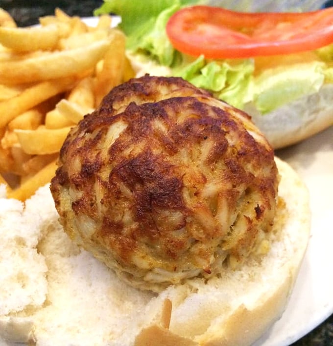 Behold the golden orb of happiness – a crab cake so perfect it deserves its own spotlight.