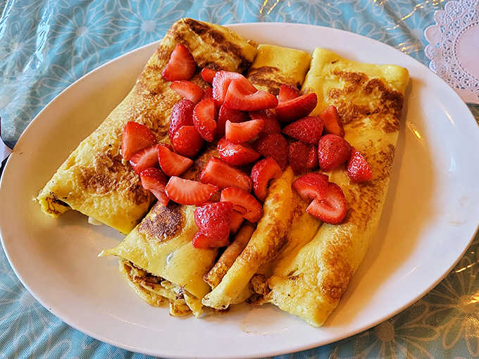 These crepes don't just arrive at your table; they make an entrance—golden-brown perfection crowned with strawberries that actually taste like strawberries.