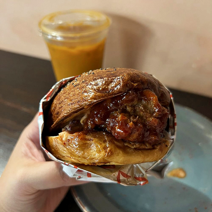 This isn't just a sandwich; it's a masterclass in texture—crispy chicken embraced by a glossy bun with sauce that demands a napkin strategy.