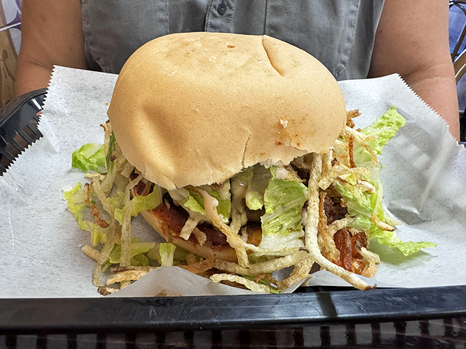 The legendary frita in all its glory—a Cuban-style burger crowned with crispy potato wisps that make regular fries seem like underachievers.
