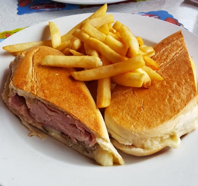 The Cuban sandwich arrives like a diplomatic mission of flavor – ham, roasted pork, and Swiss cheese negotiating perfect harmony between two crispy slices of bread.