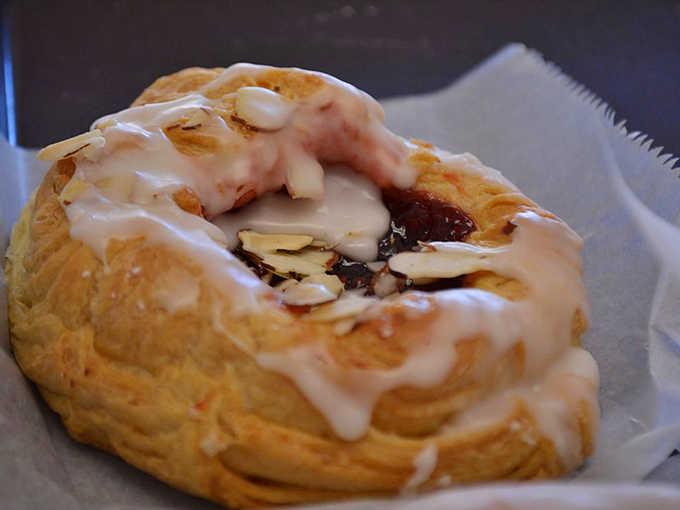 This isn't just pastry—it's edible architecture. Flaky layers cradle jam and almonds beneath a glaze so perfect it belongs in an art gallery.