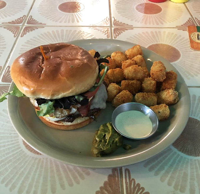 This isn't just a burger—it's architecture. The perfectly stacked creation comes with crispy tots and a side of "where have you been all my life?"