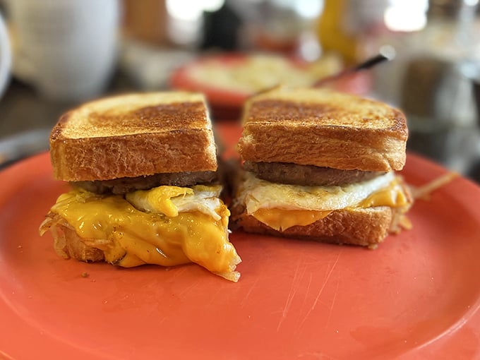 Behold the star attraction: golden-toasted bread embracing melty cheese, perfectly cooked eggs, and savory meat – breakfast architecture at its finest. 